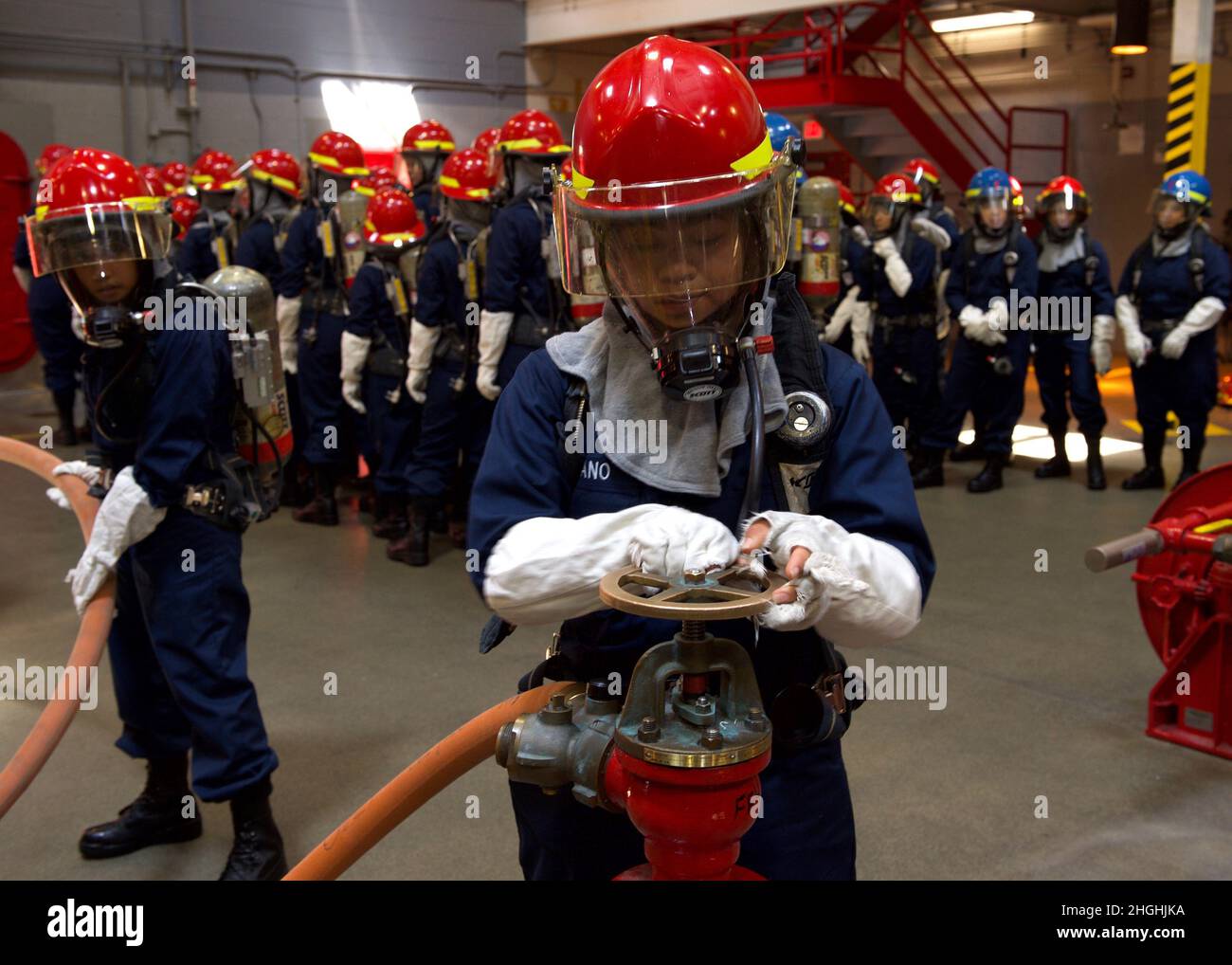 Recruits secure a water valve during a firefighting and damage control ...