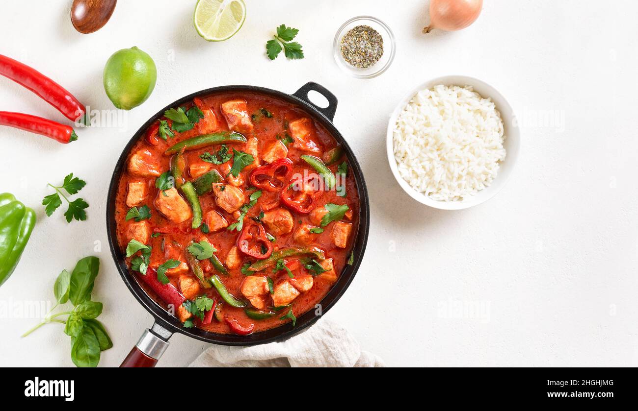 Thai style red chicken curry with vegetables over white stone ...