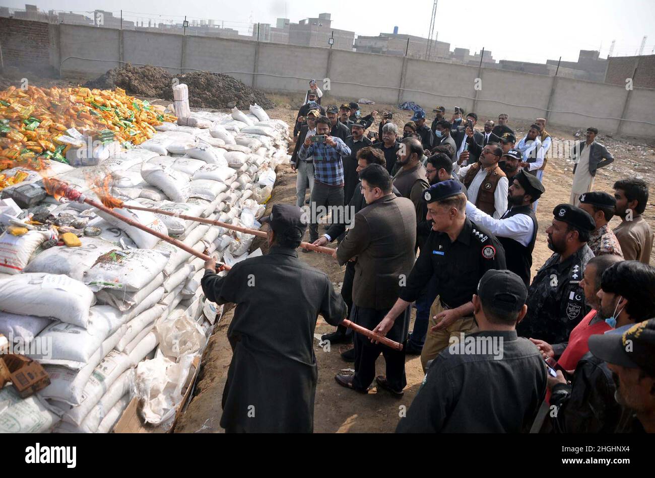 View of destroying liquor bottles and burning pile of confiscated drugs ...
