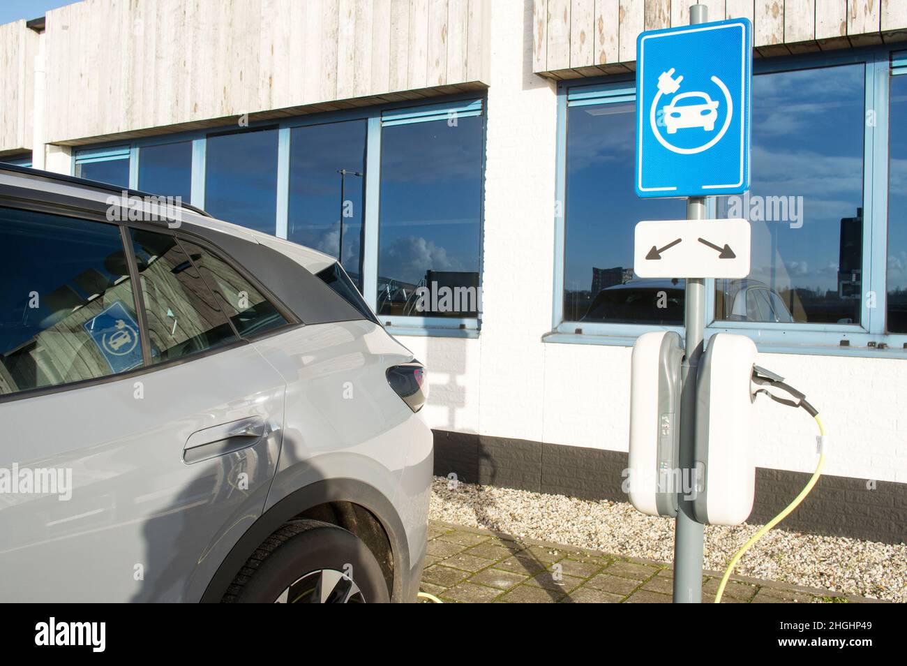 Electric car connected to charge station for charging the battery with ...