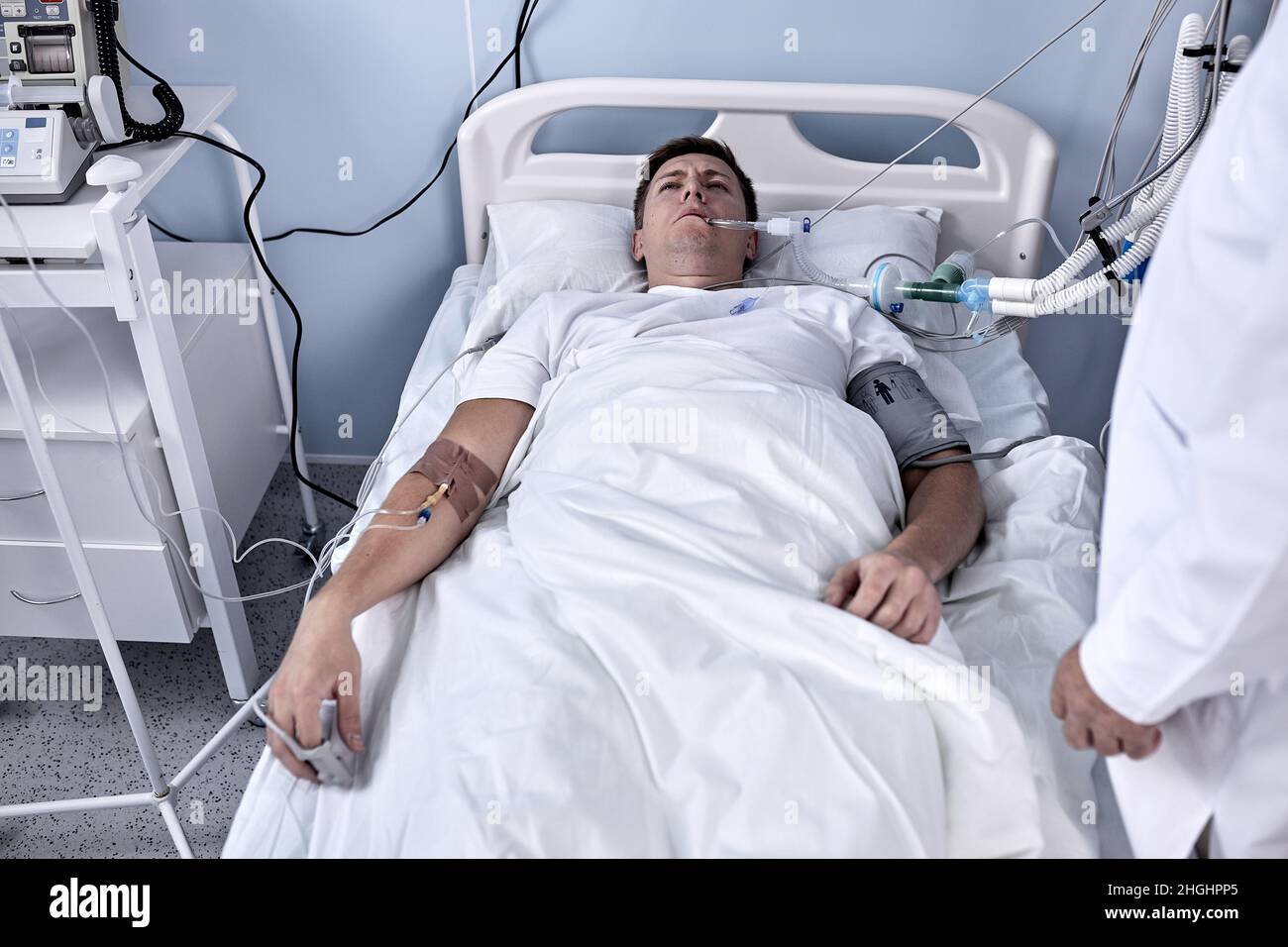 young injured man lying in bed hospital room resting from pain looking ...
