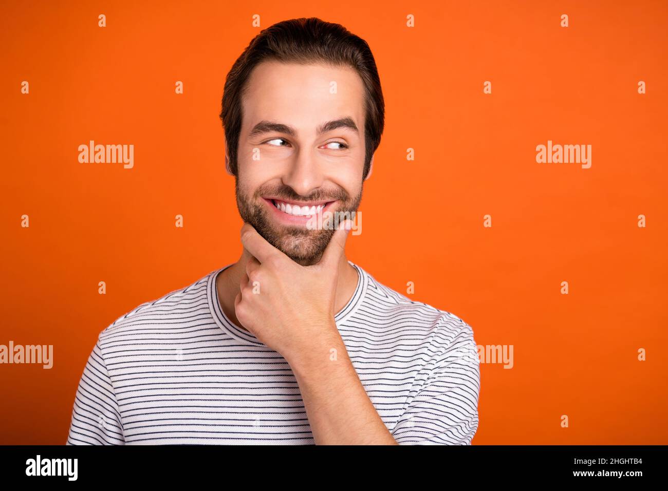 Photo of young cheerful guy arm touch chin wonderd look empty space ...