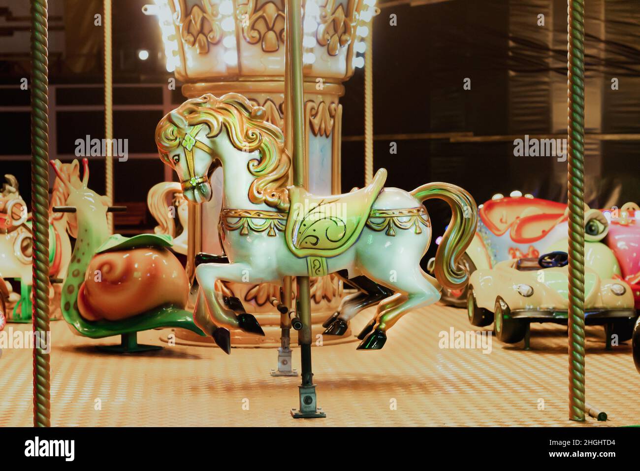 Vintage fair carousel in city amusement park. Merrygoround with horses ...