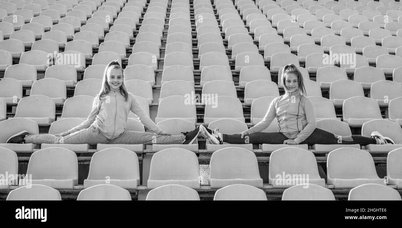 teen girls sit in split on outdoor stadium tribune, gymnastics Stock ...