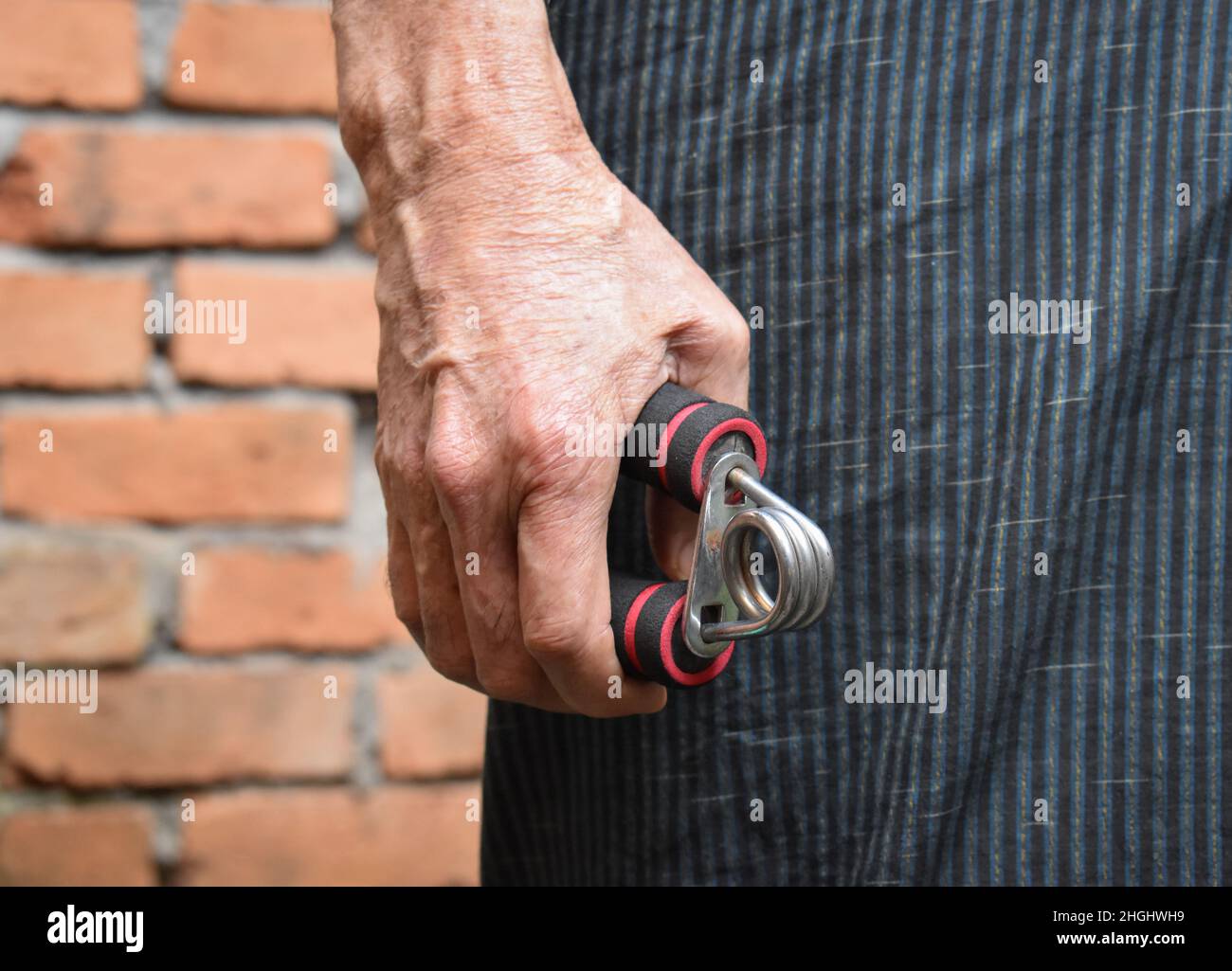 Hand of Southeast asian, Myanmar old man gripping hand exercise gripper ...