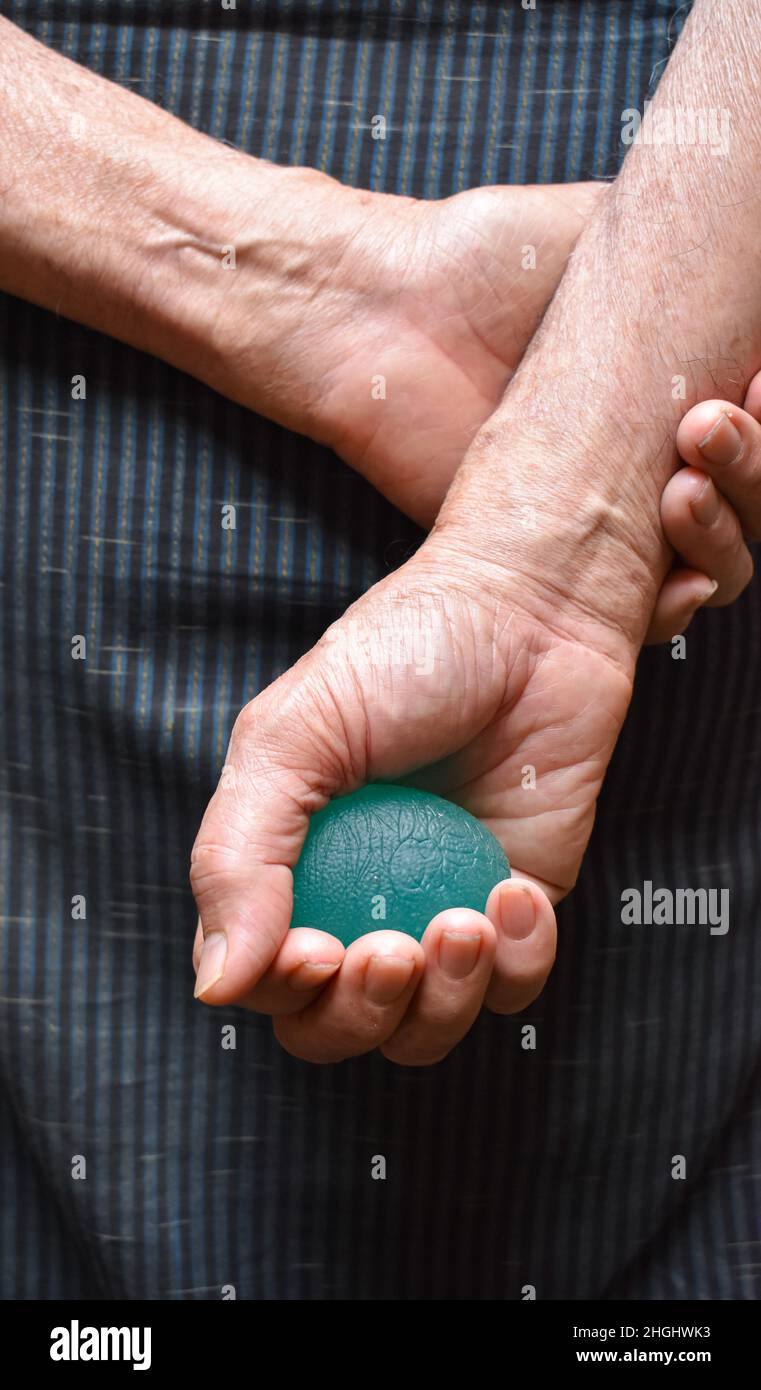Southeast asian, Myanmar old man gripping hand exercise elastic ball ...