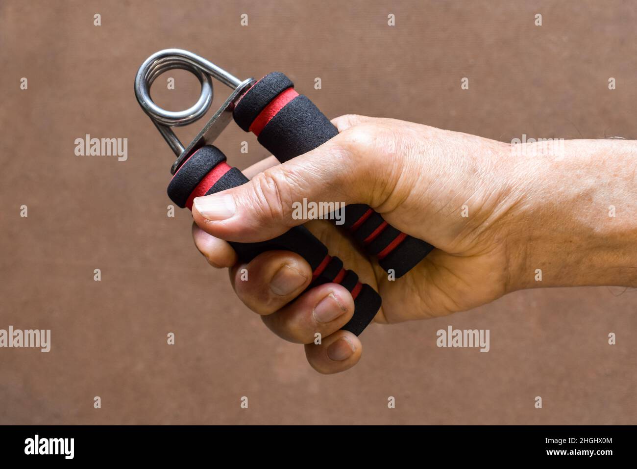 Hand of Southeast asian, Chinese old man gripping hand exercise gripper ...