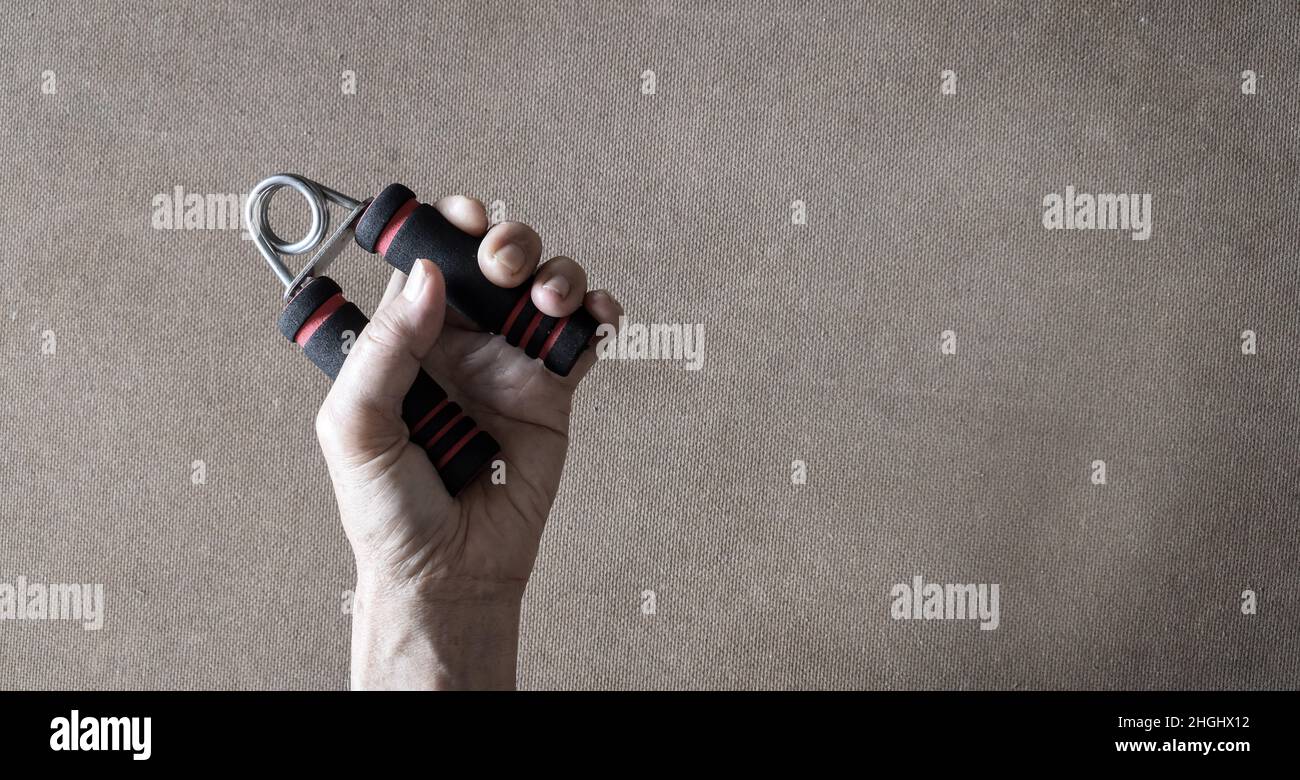 Hand of Southeast asian, Chinese old man gripping hand exercise gripper ...