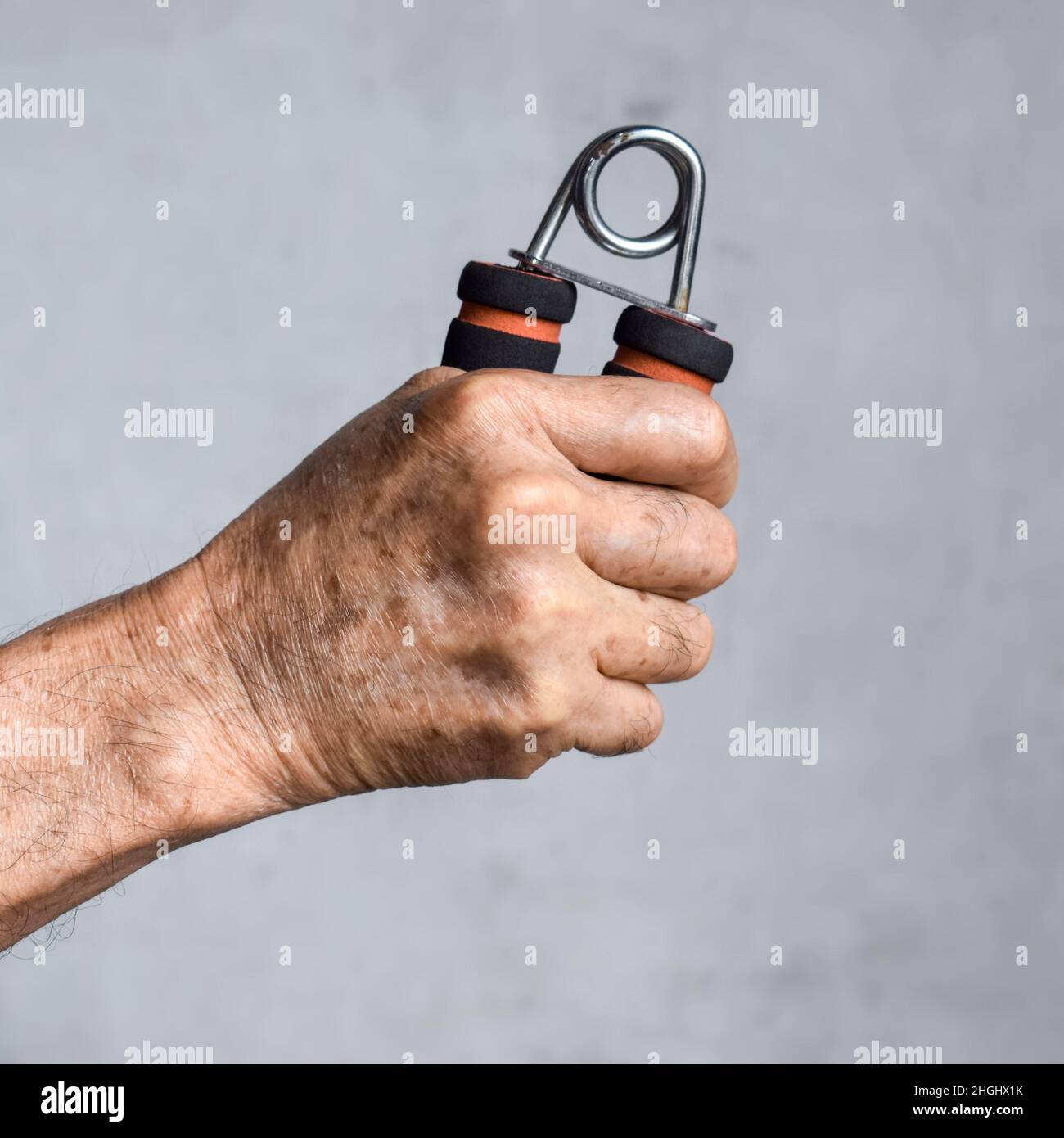 Hand of Southeast asian, Chinese old man gripping hand exercise gripper ...