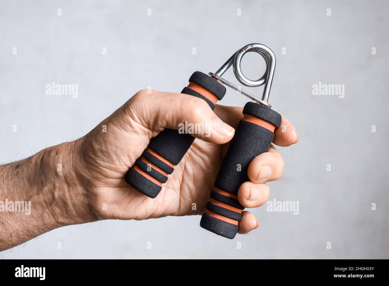 Hand of Southeast asian, Chinese old man gripping hand exercise gripper ...