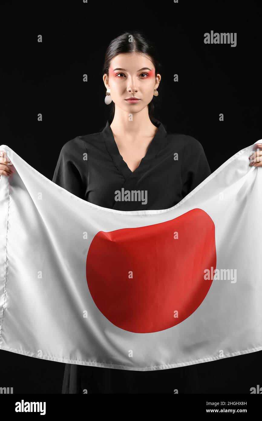 Beautiful young woman with flag of Japan on black background Stock ...