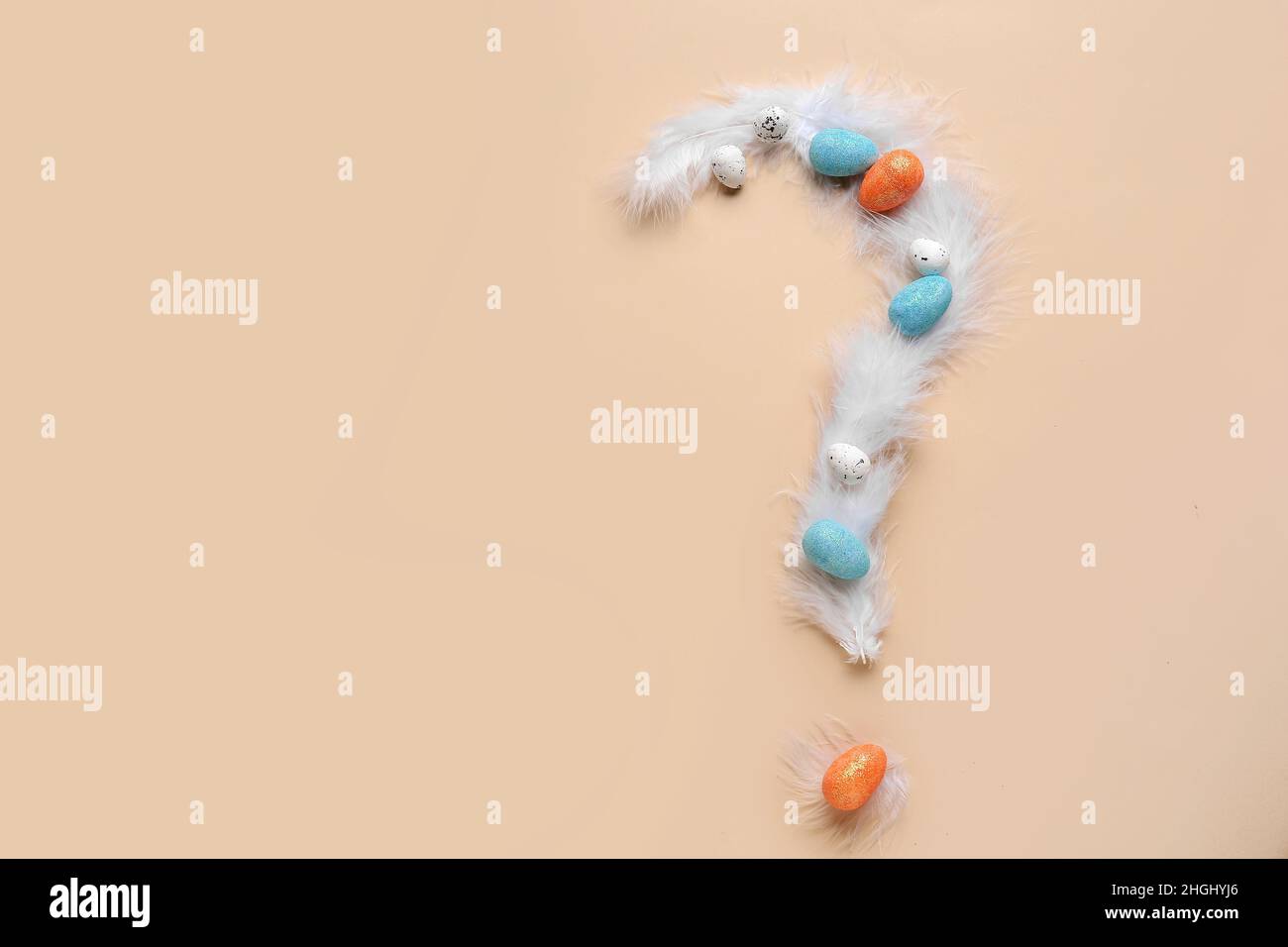 Question mark made of feathers and decorative eggs on color background ...