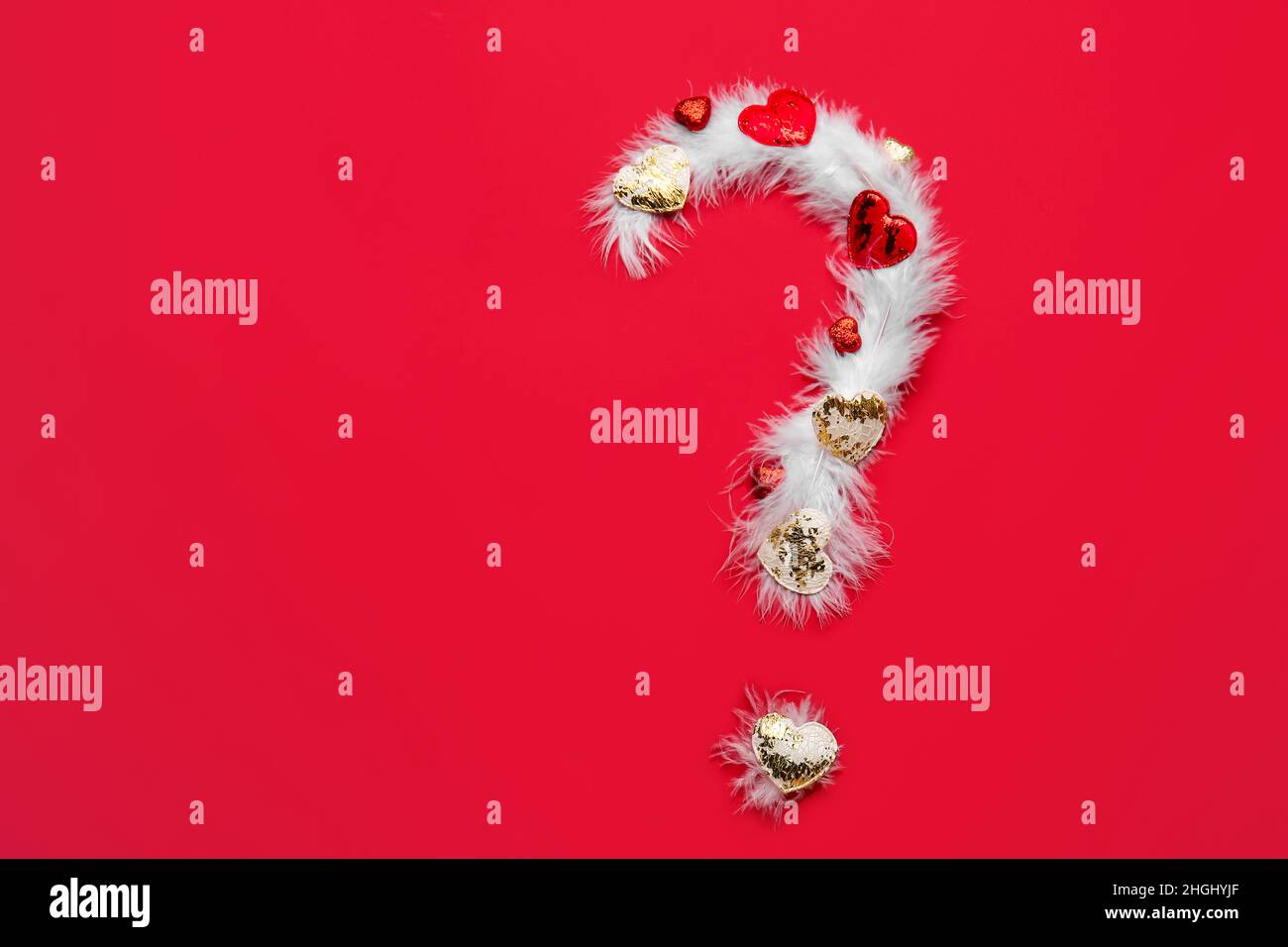 Question mark made of feathers and little hearts on color background ...