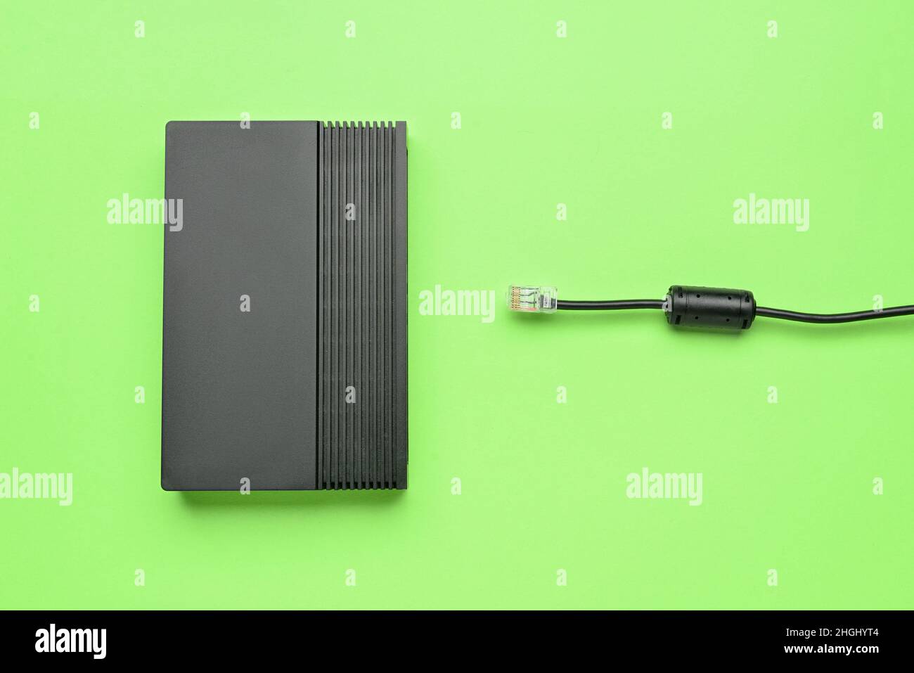 Wi-fi router and internet cable on green background Stock Photo - Alamy