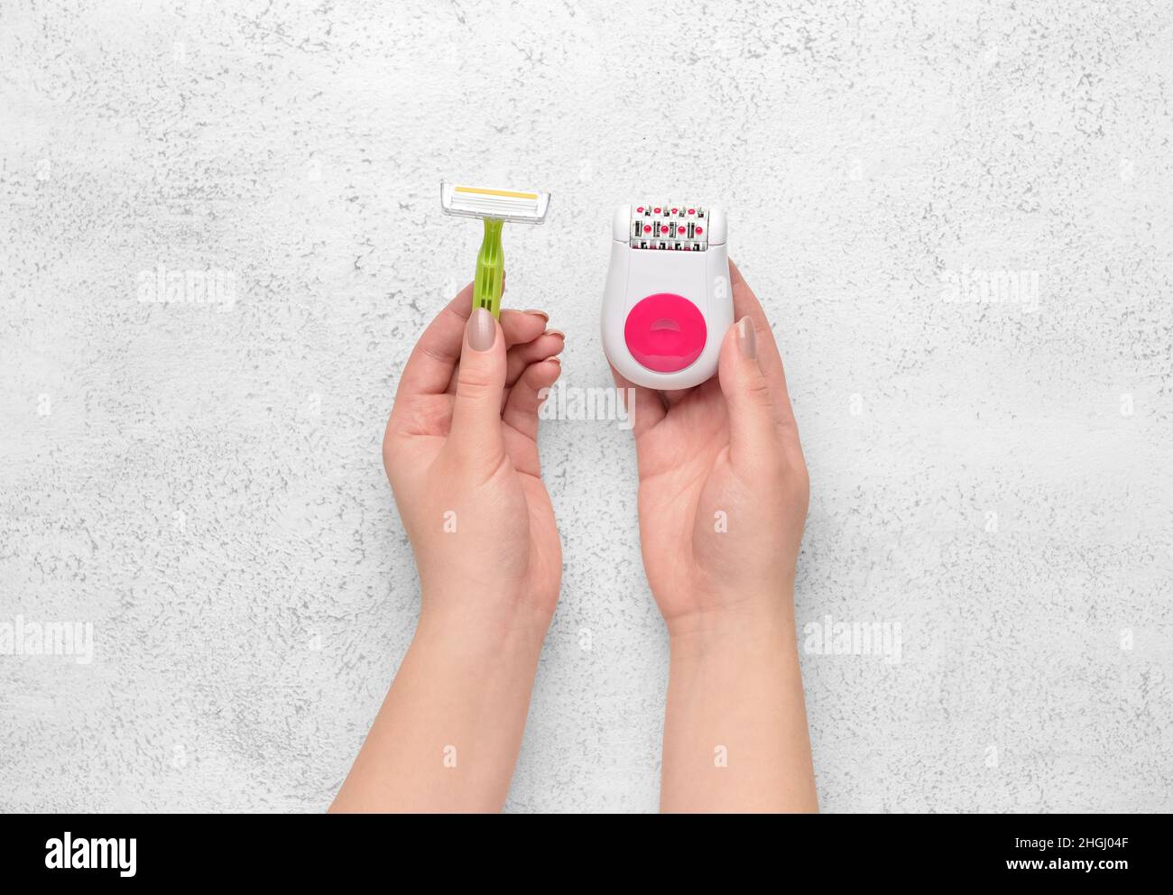 Female hands with modern epilator and razor on light background Stock ...