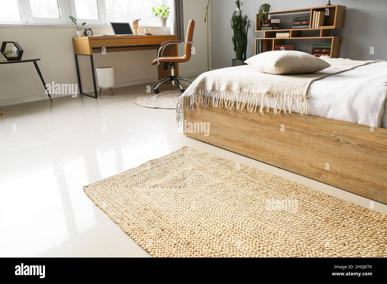 Stylish wicker rug on floor in modern bedroom Stock Photo - Alamy