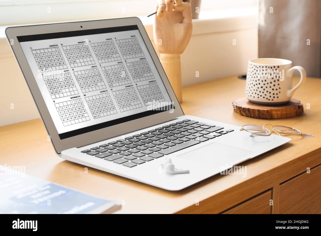 Modern workplace with calendar on screen of laptop near window Stock ...