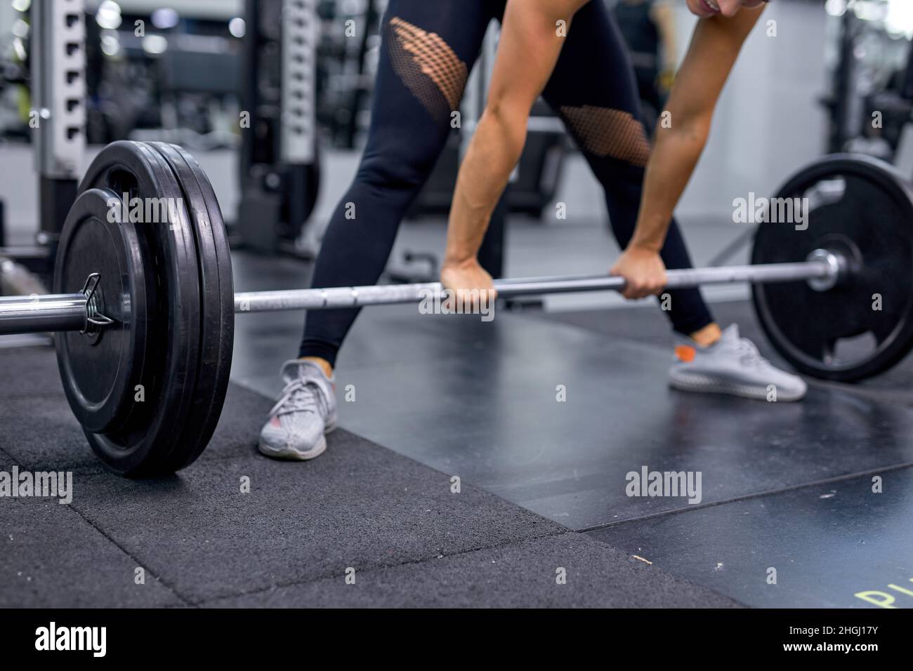 cropped Female bodybuilder doing exercise with heavy weight bar ...