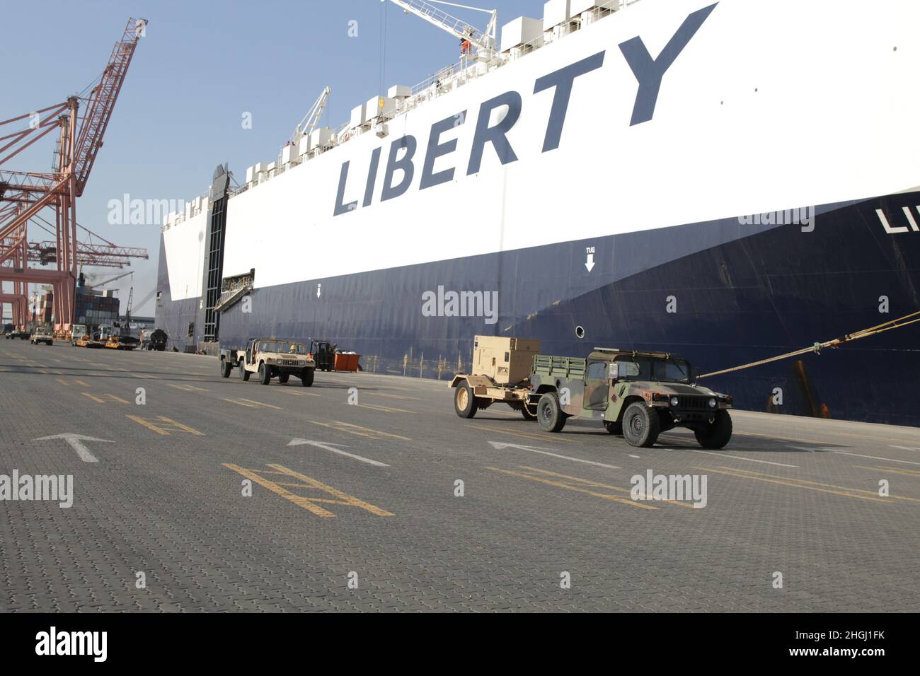 Port of Shuaiba dock workers move vehicles from the ship to shore ...