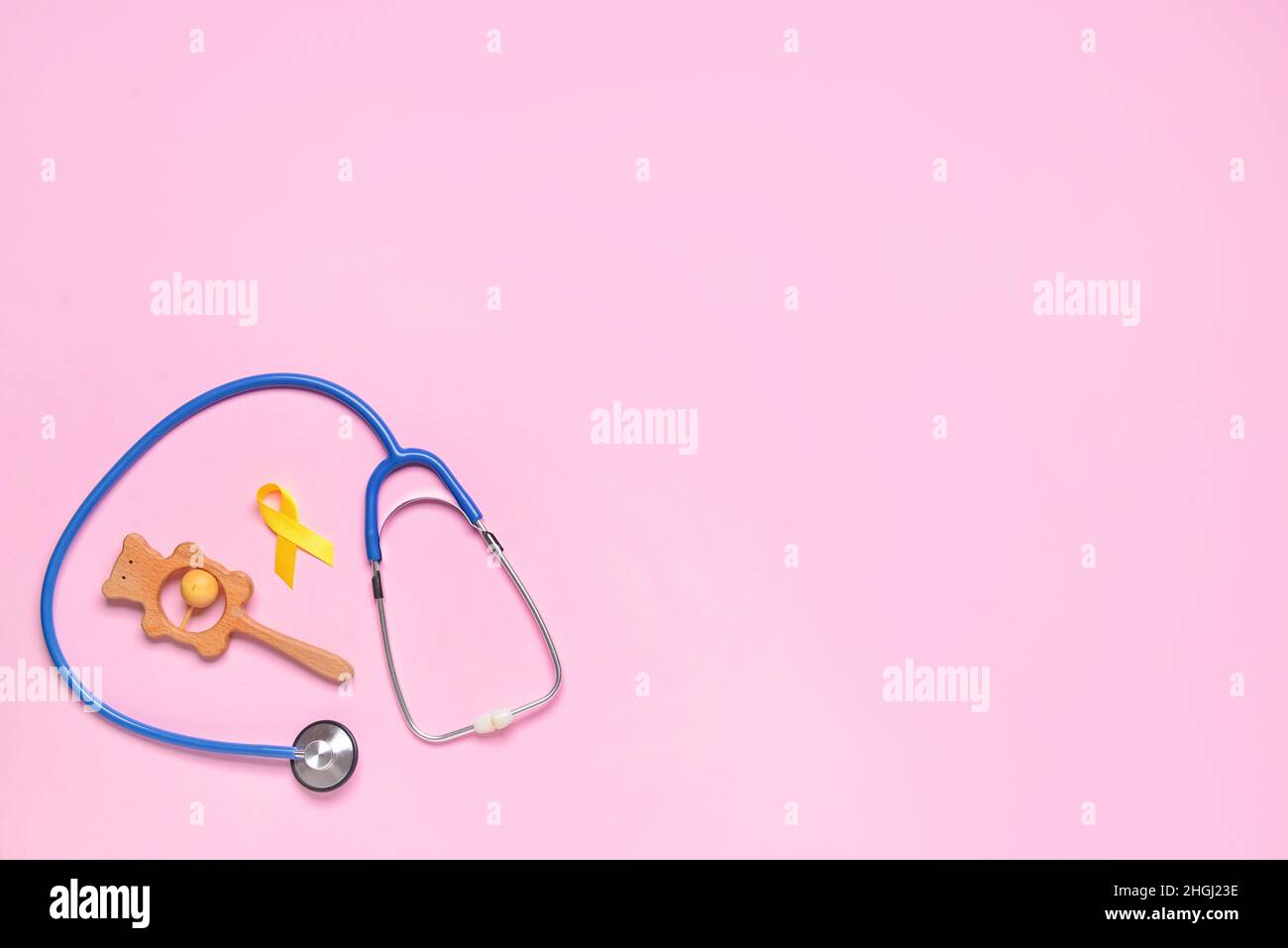Golden awareness ribbon, rattle and stethoscope on color background ...