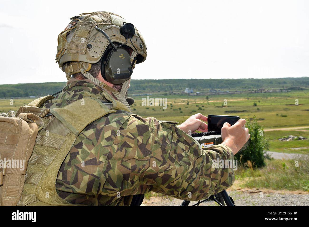 A Latvian Special Operation Forces member places a laser target using ...