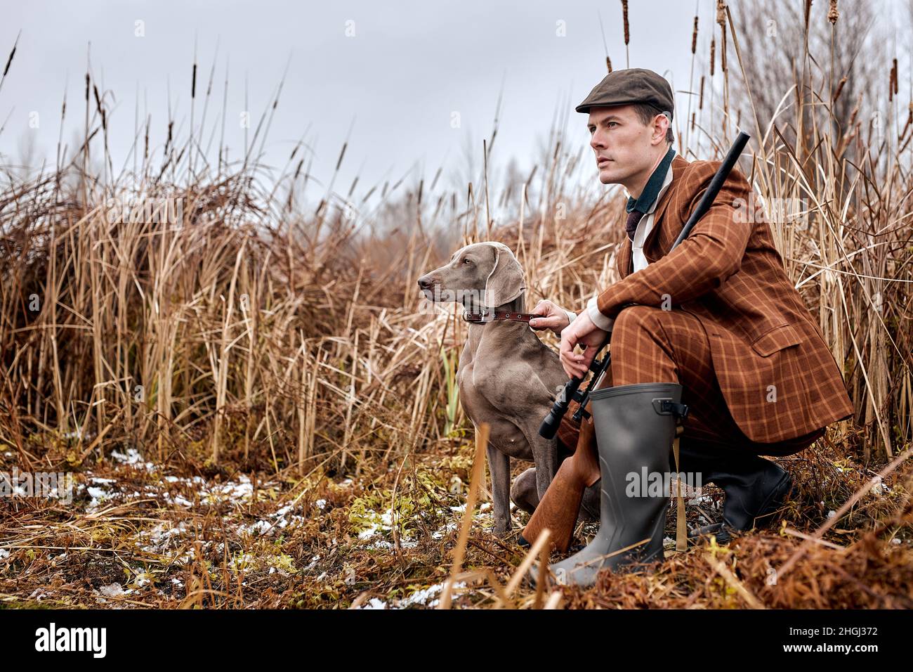 caucasian male hunter in suit clothes ready to hunt, holding gun and ...