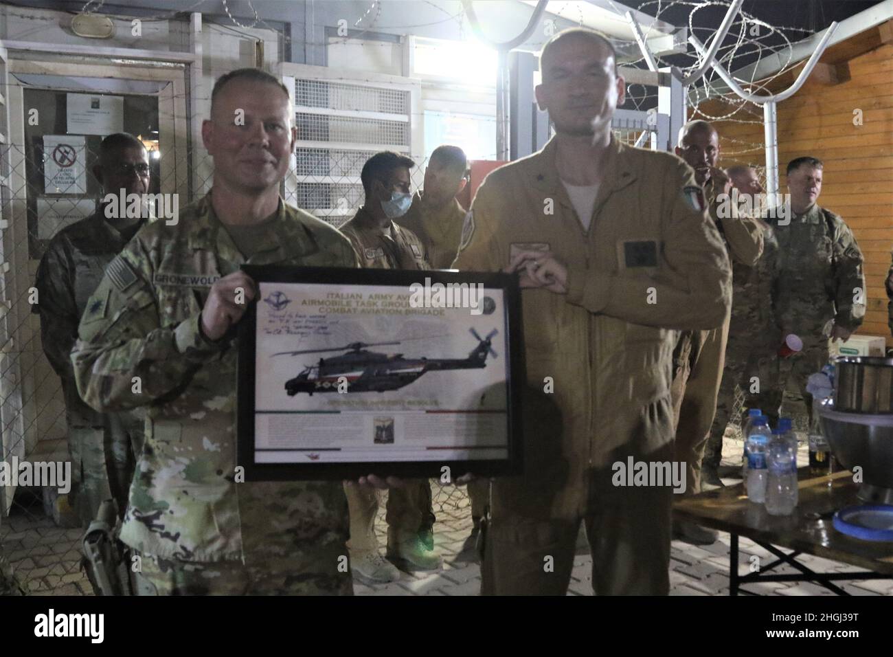 Task Force Phoenix commander Col. Alan Gronewold is presented a gift by ...