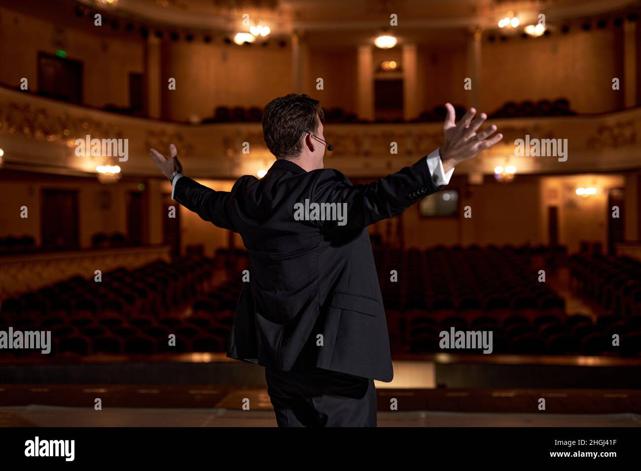 Showman. Middle Age Male entertainer, presenter or actor on stage. Arms ...