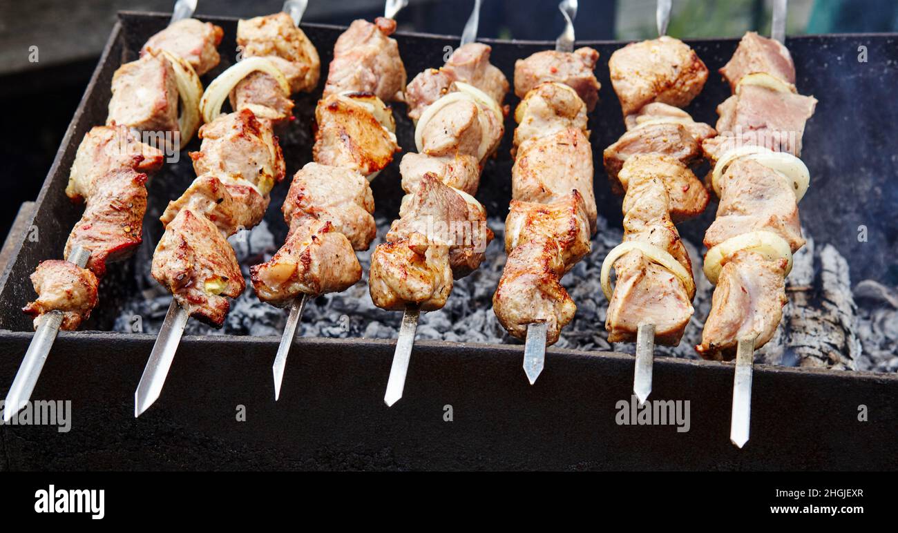 Marinated shashlik preparing on a barbecue grill over charcoal ...