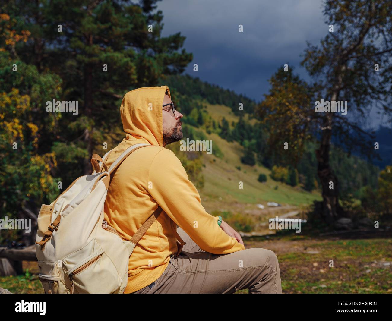 Man resting after hike with beautiful view of snowy mountain peaks ...