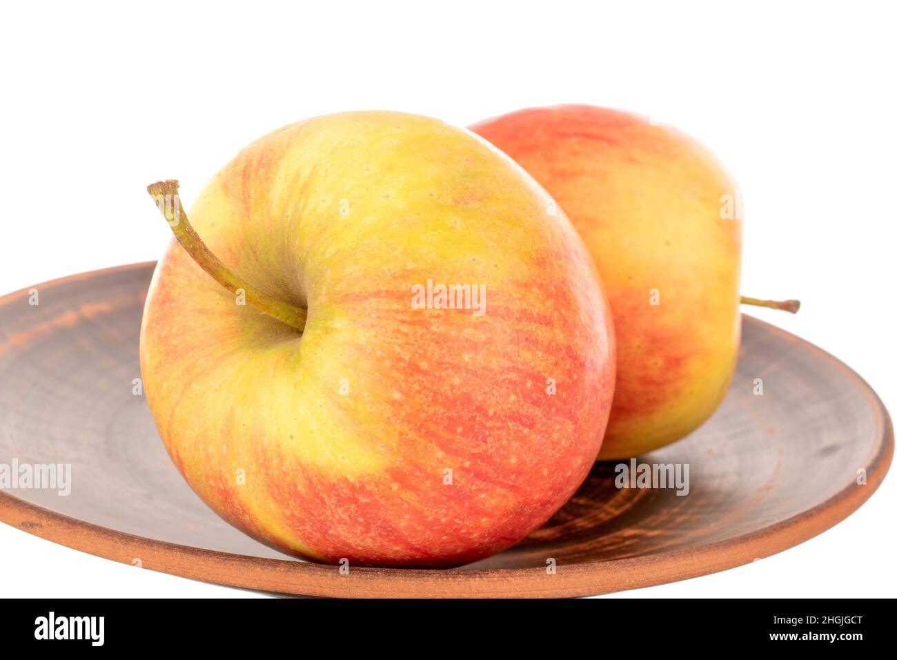 Three red juicy apples on a clay plate, macro, isolated on white Stock ...