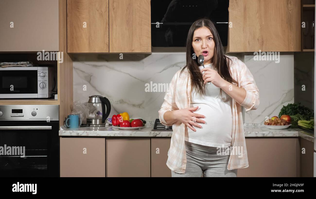 Pregnant woman sings with spoon imitating microphone dances Stock Photo ...