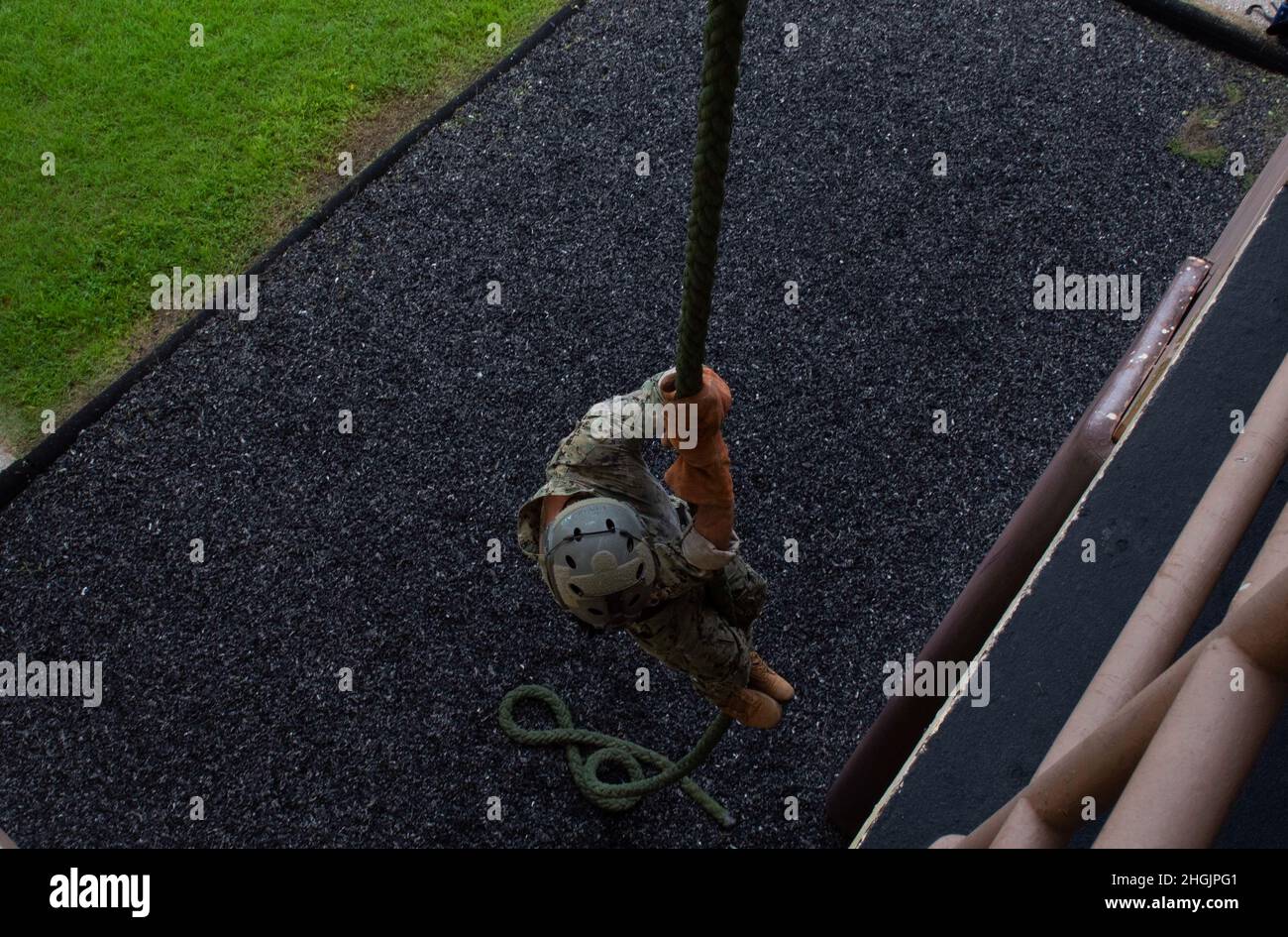 A U.S. Naval Special Warfare operator practices fast-rope techniques ...