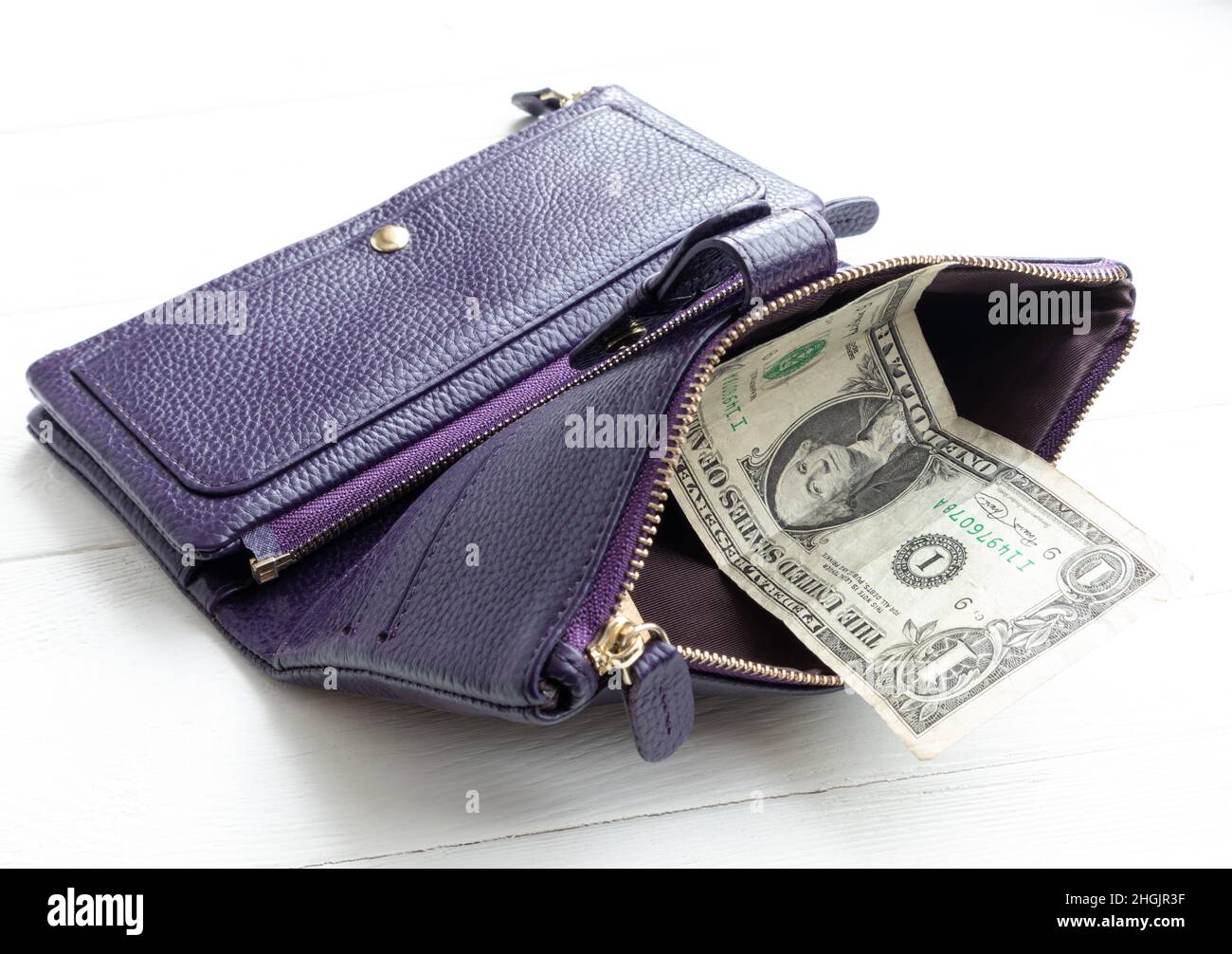 Purple zipper money wallet with a banknote inside, on a white ...
