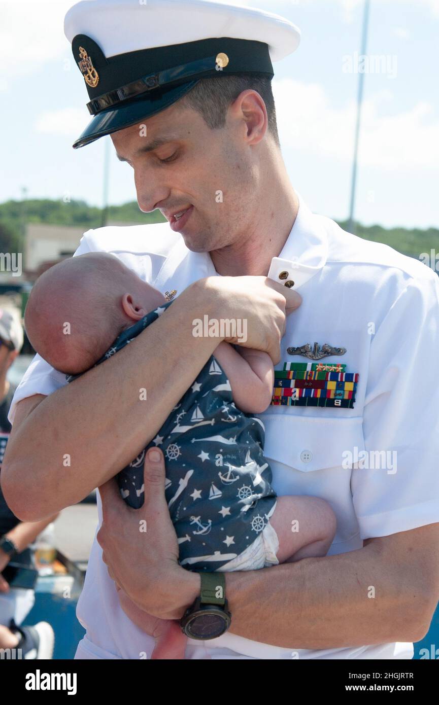 Chief Petty Officer David Begley holds his son Ben for the first time ...