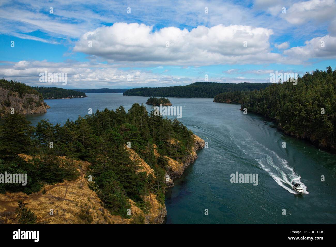 A pleasure boat cruises through Deception Pass in Washington state ...
