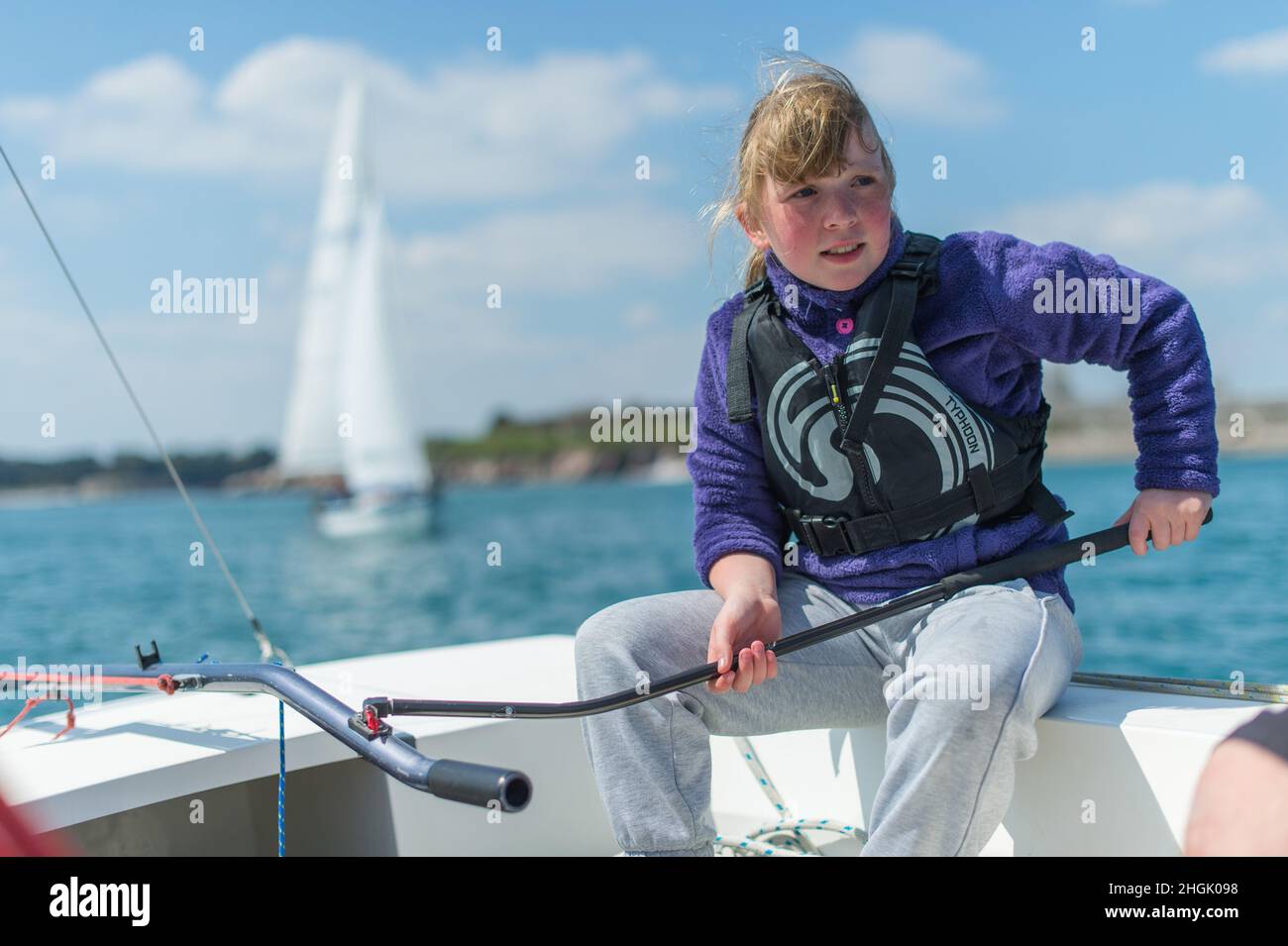A young girl on a sailing lesson on a boat Stock Photo - Alamy