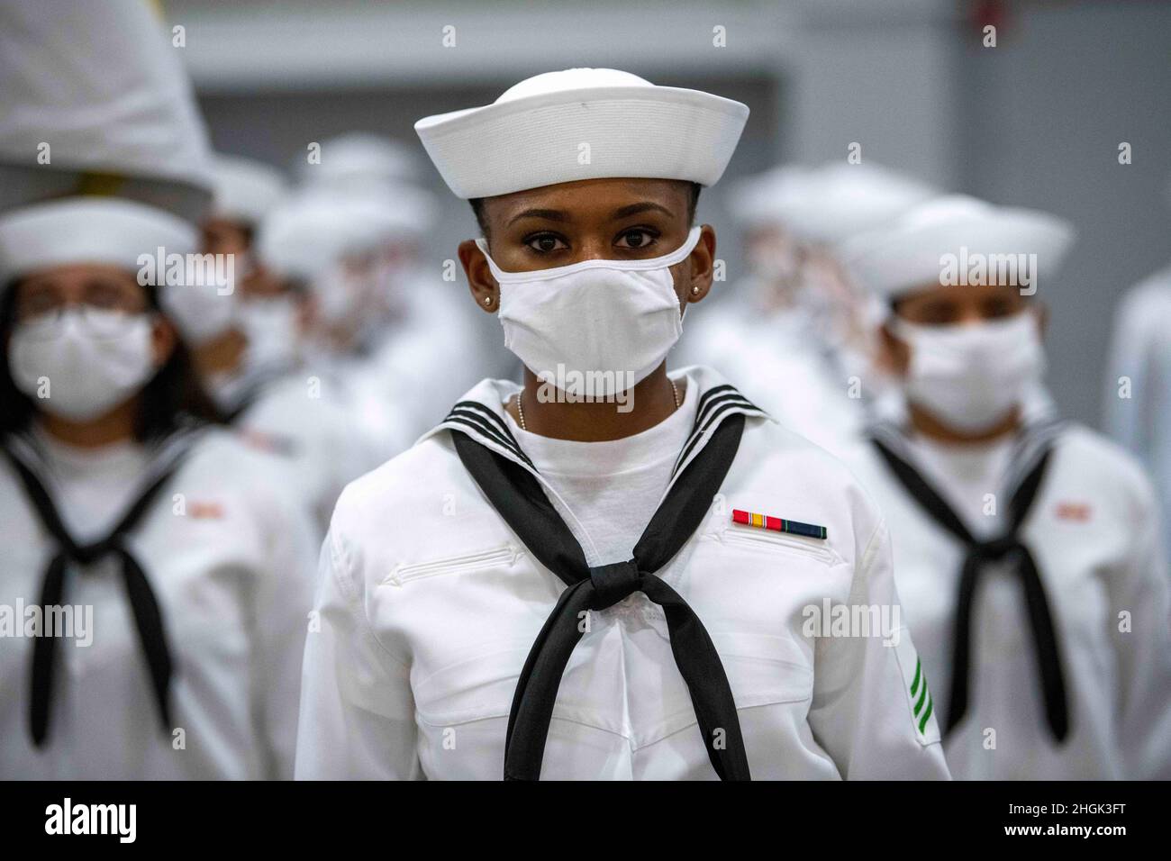 A graduating Sailor sings "Anchors Aweigh" during a pass-in-review ...