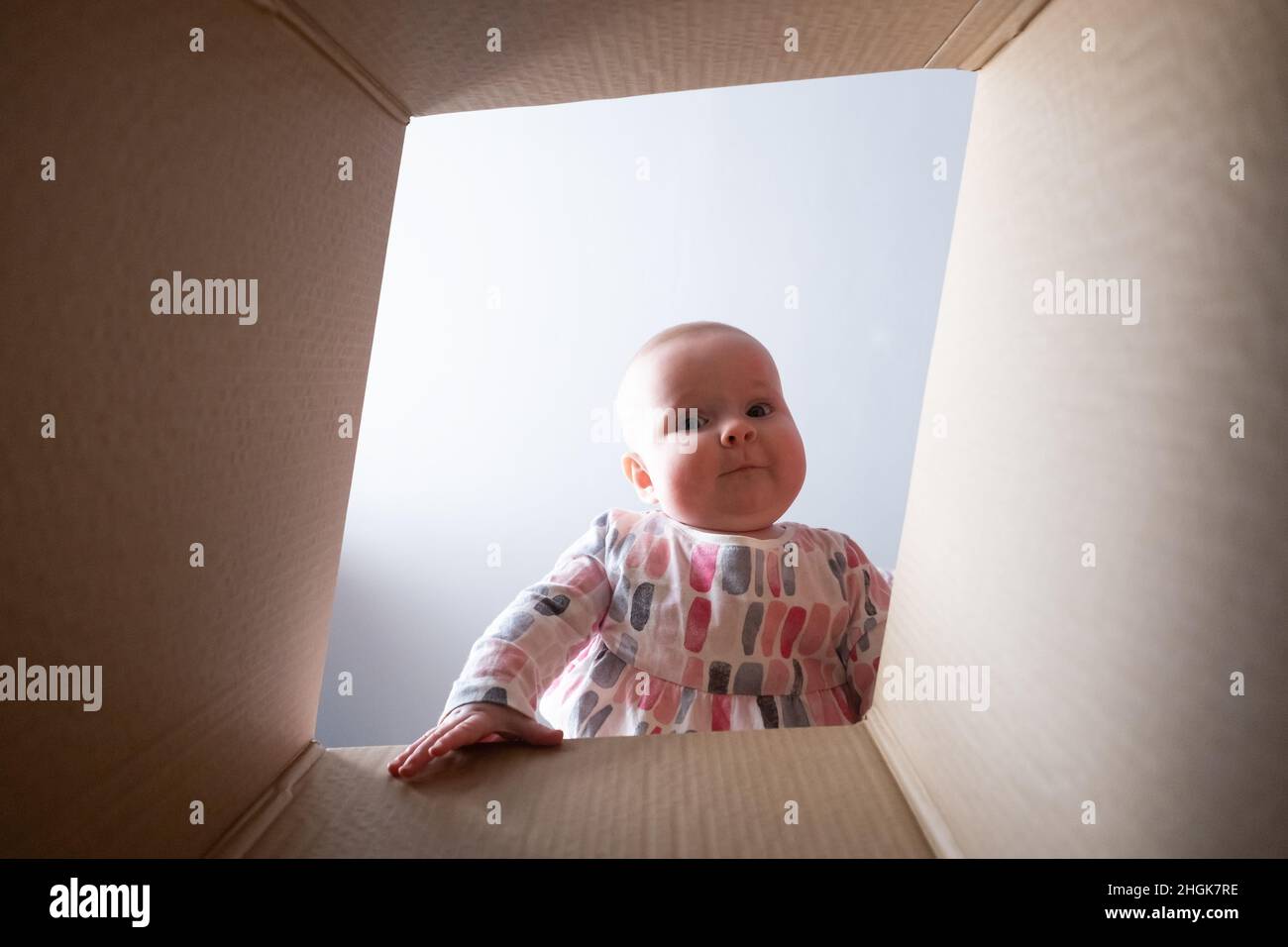 Happy baby into parcel cardboard box and smiling Stock Photo - Alamy