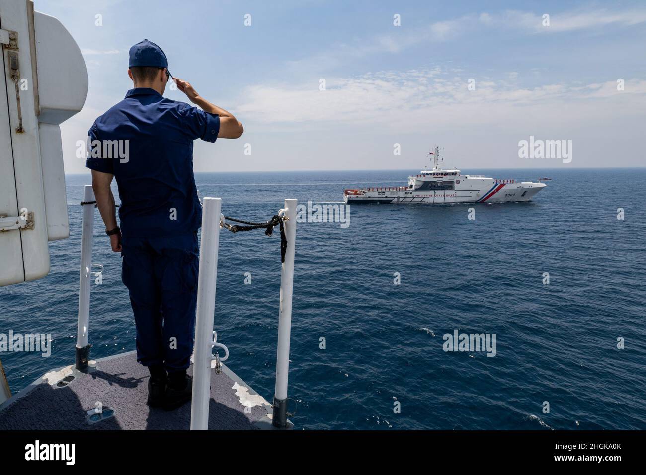 A crewmember from the U.S. Coast Guard Cutter Munro salutes a ...
