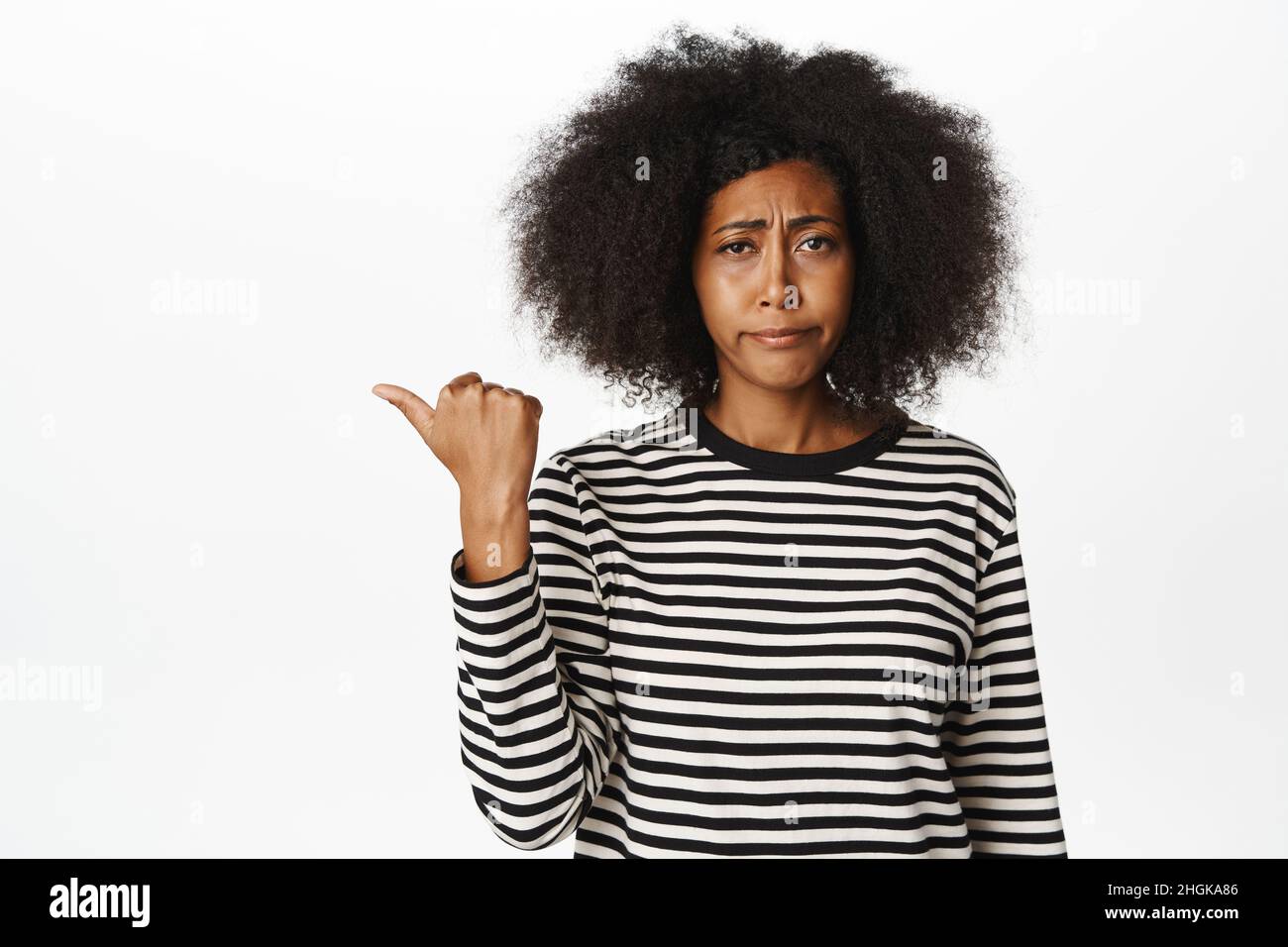 Close up of skeptical african female model frowning, looking displeased ...