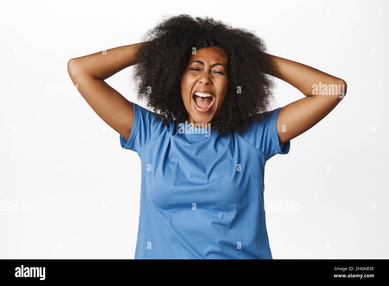 Portrait of distressed african american woman screaming and pulling ...
