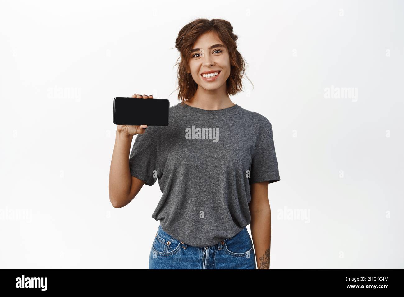 Happy smiling girl shows horizontal phone screen, mobile app interface ...