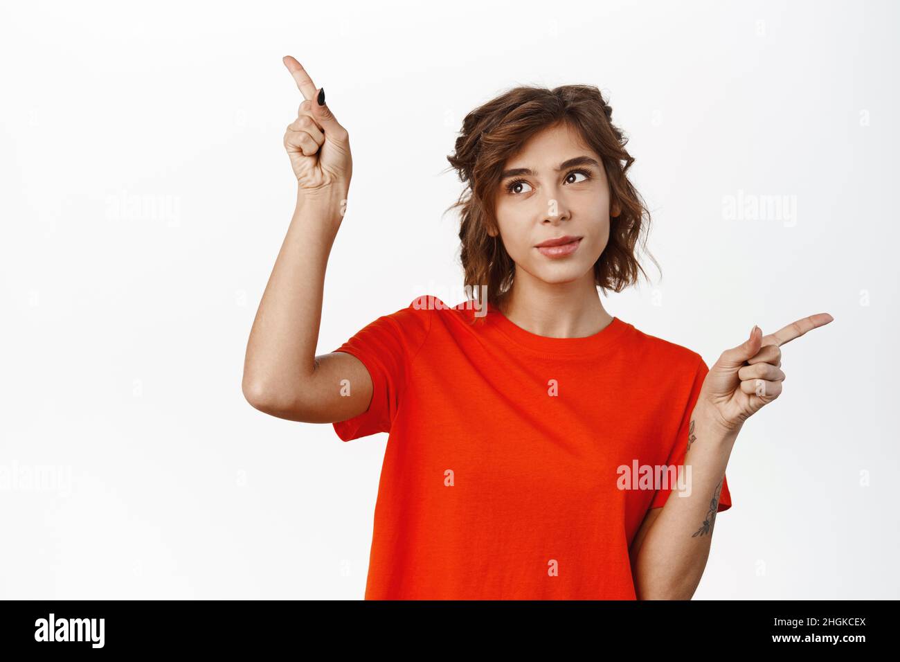 Portrait of young brunette woman choosing between two variants, making ...