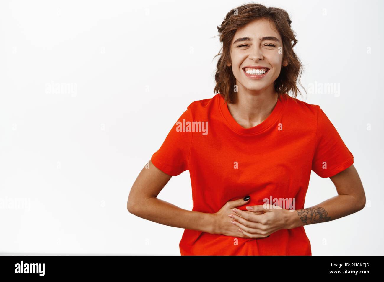 Portrait of beautiful happy girl laughing, holding hands on belly ...