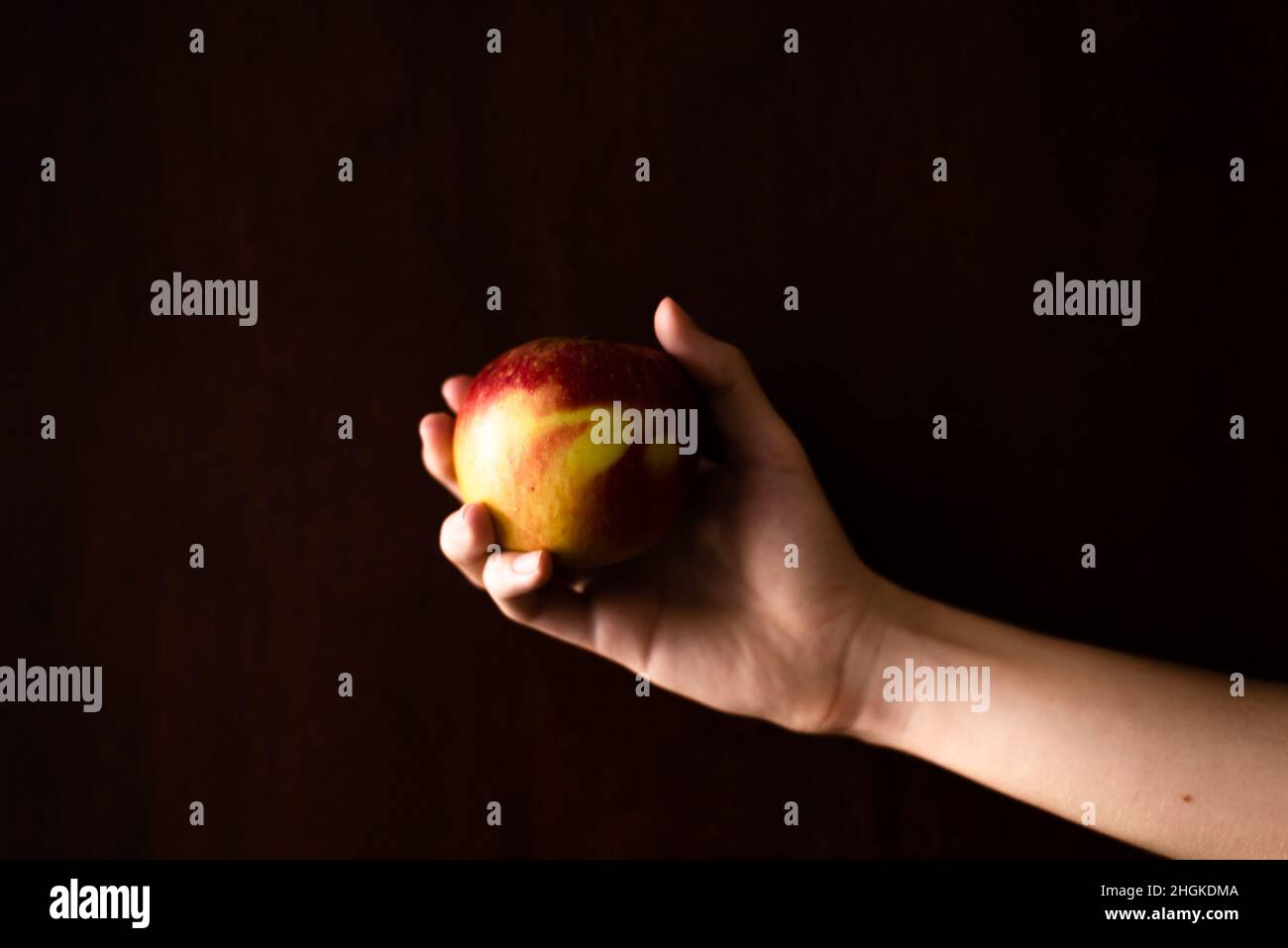 Hand holding red apple dark hi-res stock photography and images - Alamy