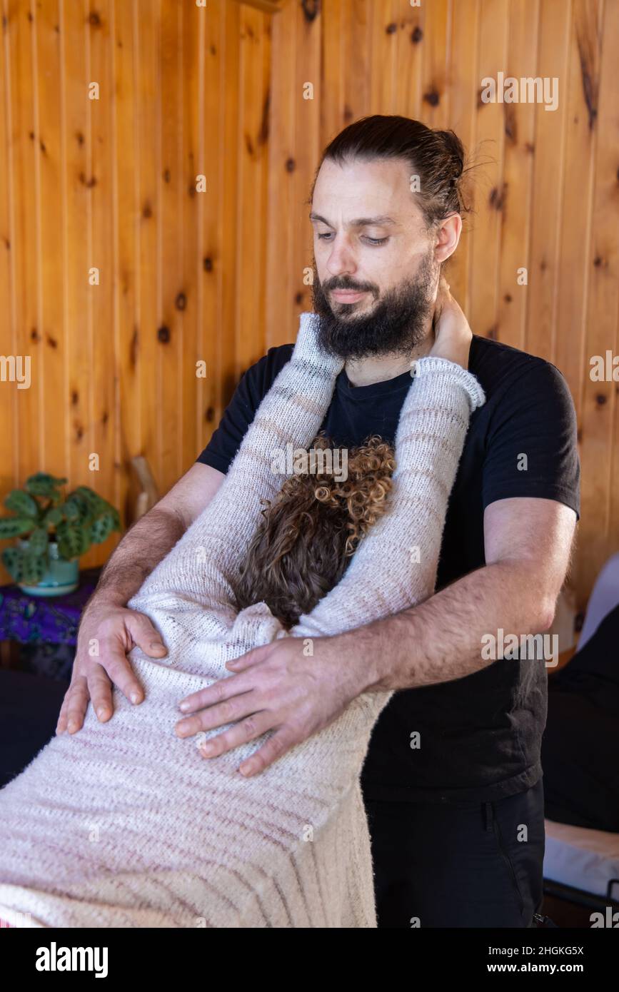 A male physician is seen performing chiropractic technique on woman ...