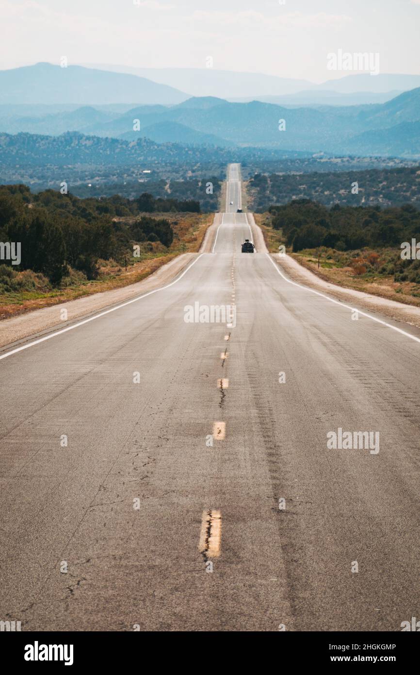 a highway stretches straight over rolling hills into the distance on ...