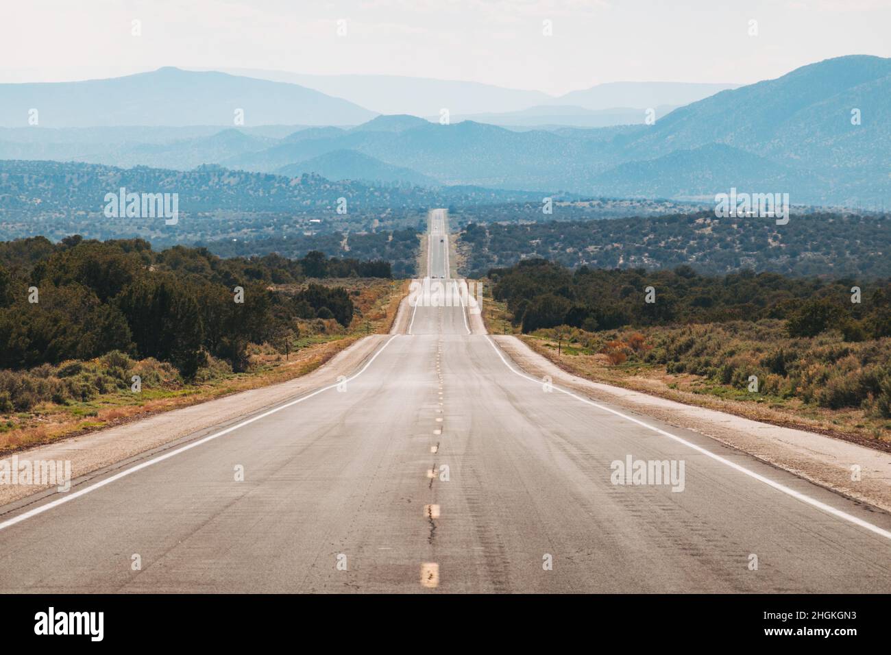a highway stretches straight over rolling hills into the distance on ...