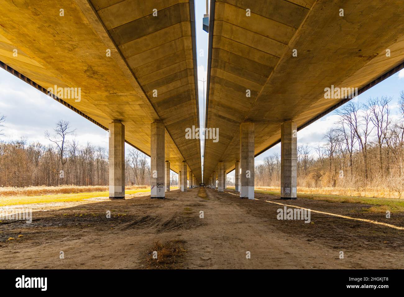 Central view from under of highway bridge with high concrete pillars ...